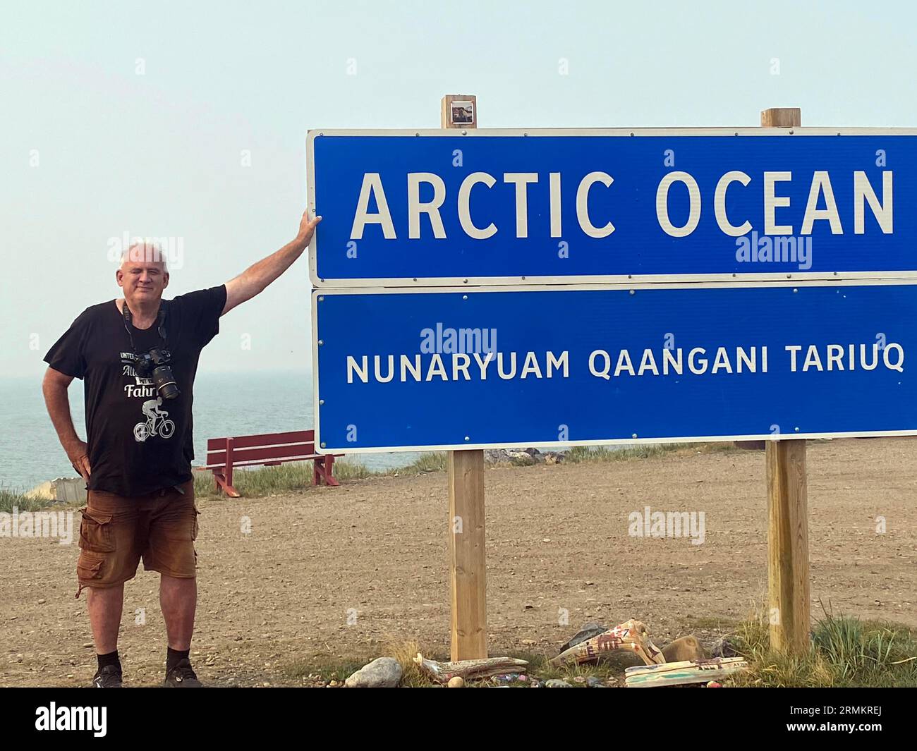 Tourist in front of sign Arctic Ocean, Tuktojaktuk, Arctic Ocean ...