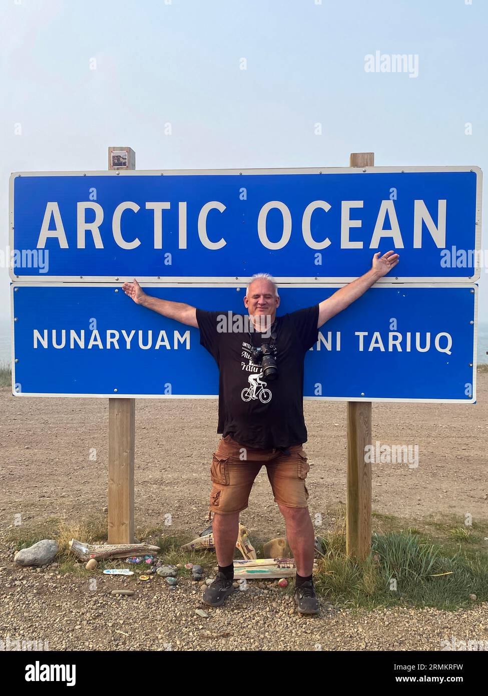 Tourist in front of sign Arctic Ocean, Tuktojaktuk, Arctic Ocean ...