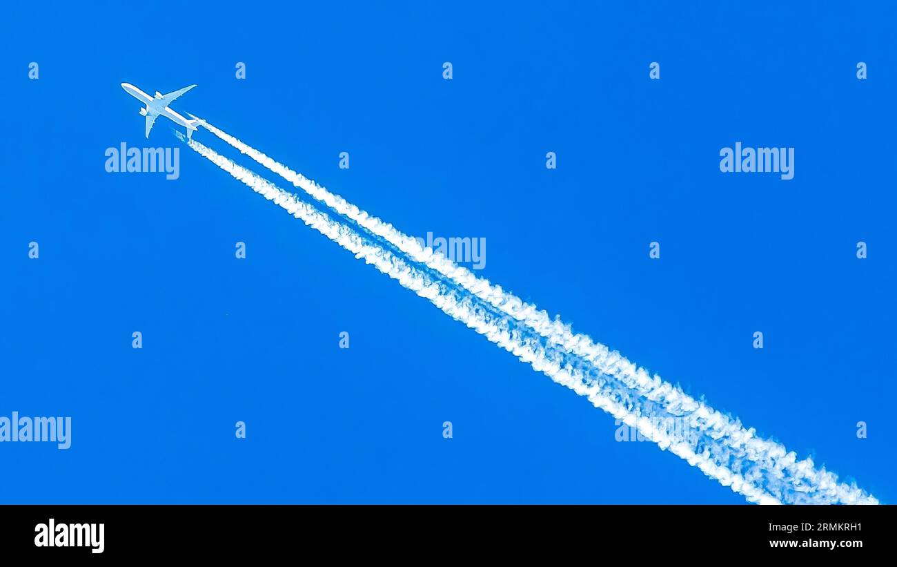 Two engined airplane during flight with condensation trails Stock Photo ...