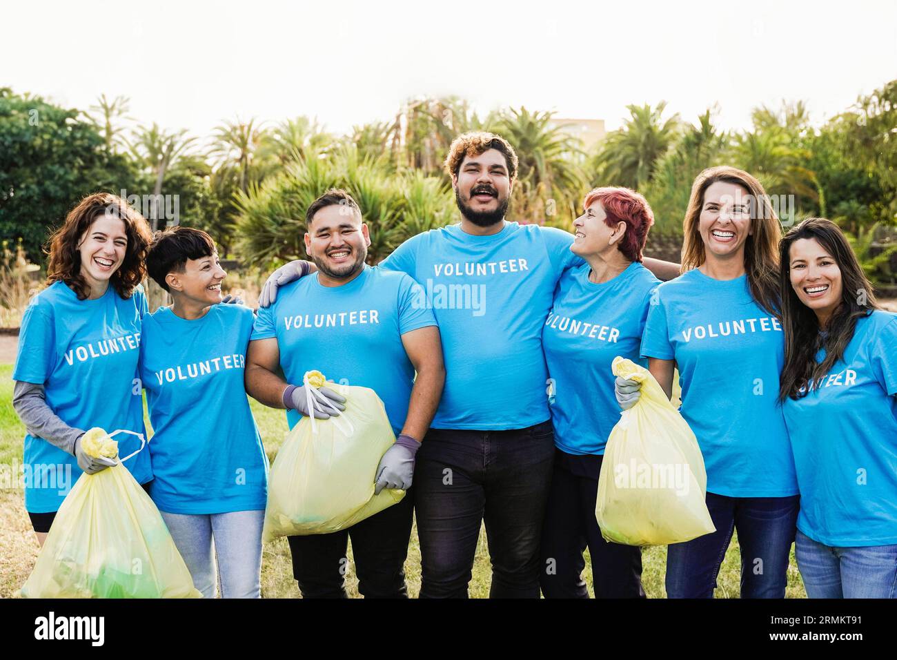 Happy volunteers helping community clean and recycle plastic at nature ...
