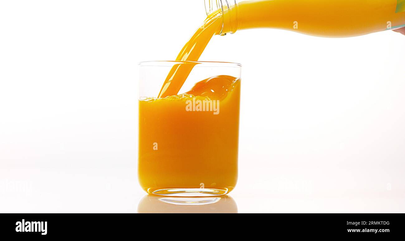 Orange Juice being poured into Glass against White Background Stock ...