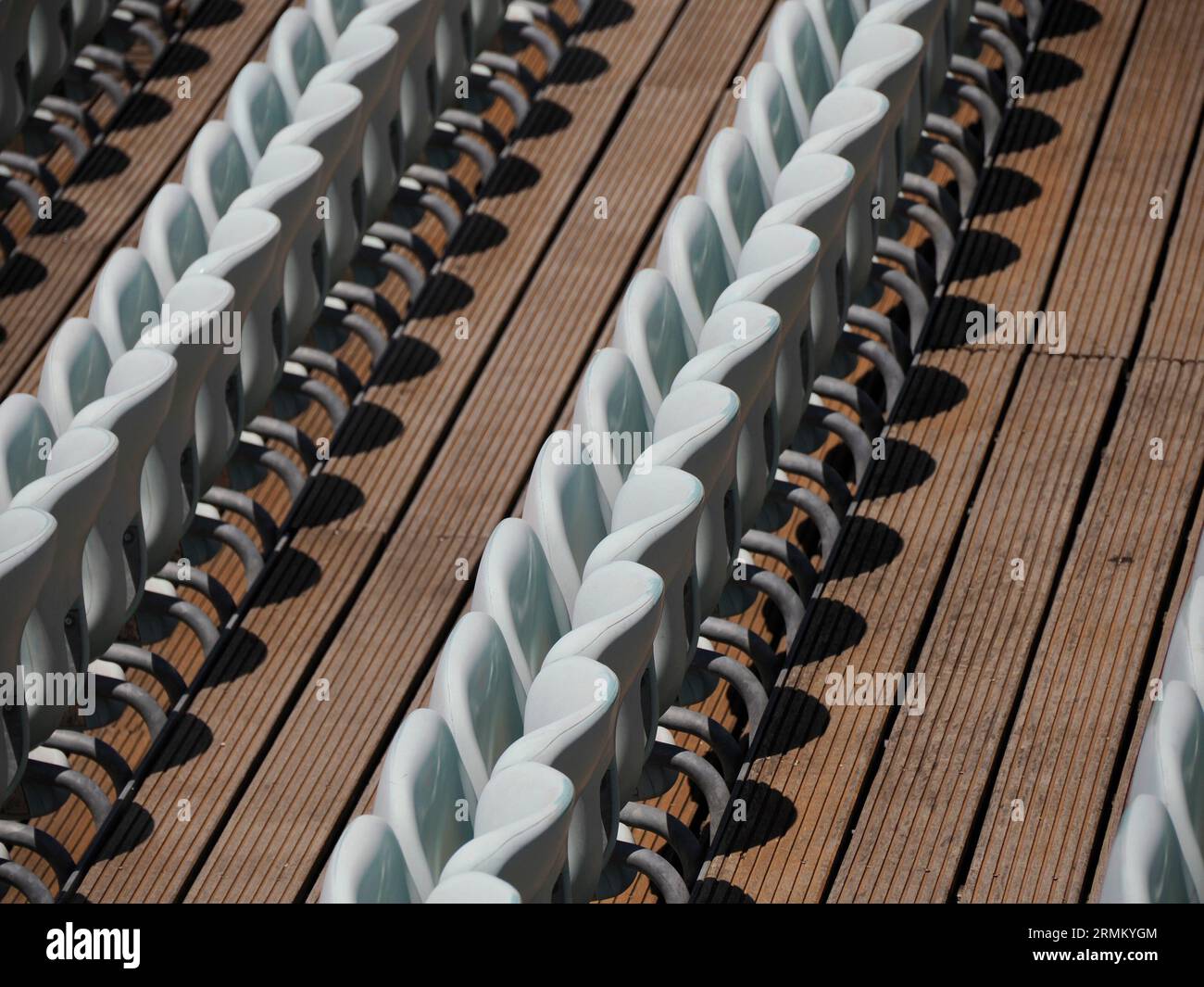 Rows of numbered empty plastic seats at an open-air amphitheater many ...