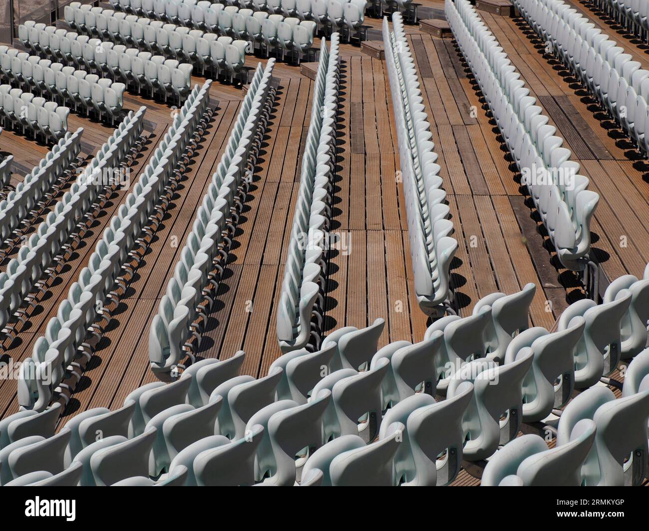 Rows of numbered empty plastic seats at an open-air amphitheater many ...