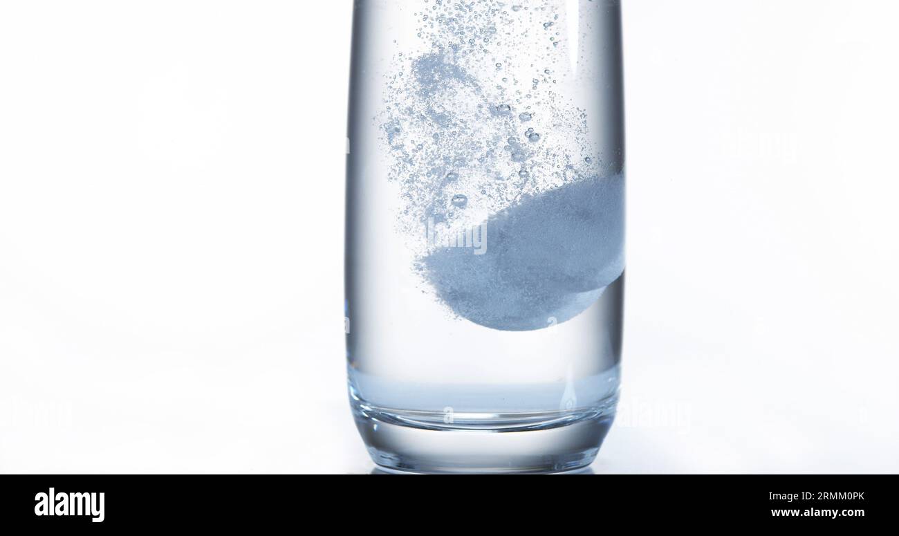 Tablets Falling and Dissolving into a Glass of Water against White ...