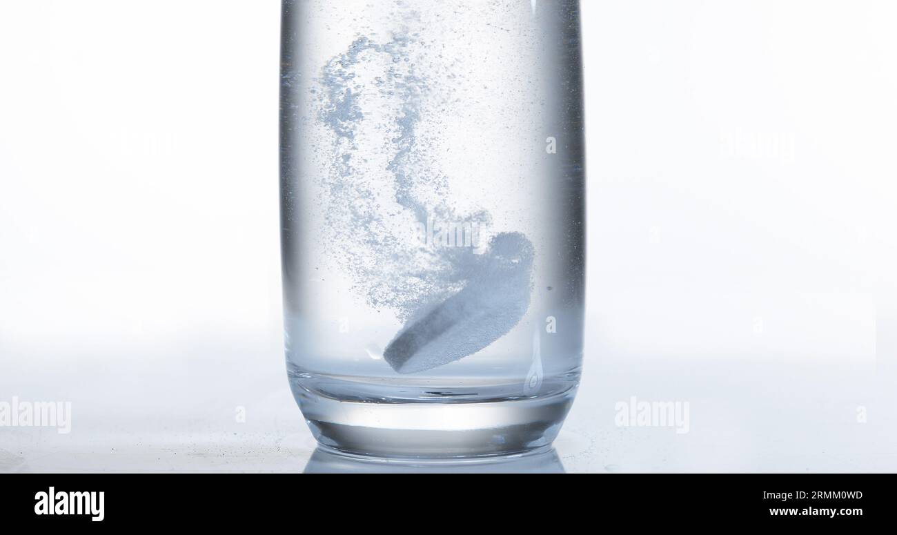 Tablets Falling and Dissolving into a Glass of Water against White ...