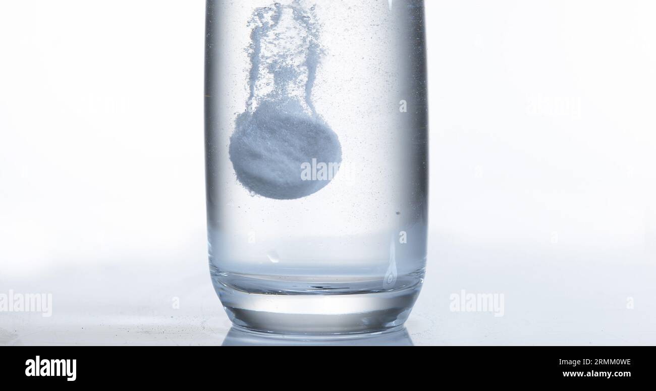 Tablets Falling and Dissolving into a Glass of Water against White ...