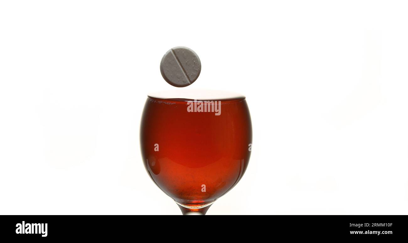 Tablet Falling into a Glass of red Wine against White Background Stock ...