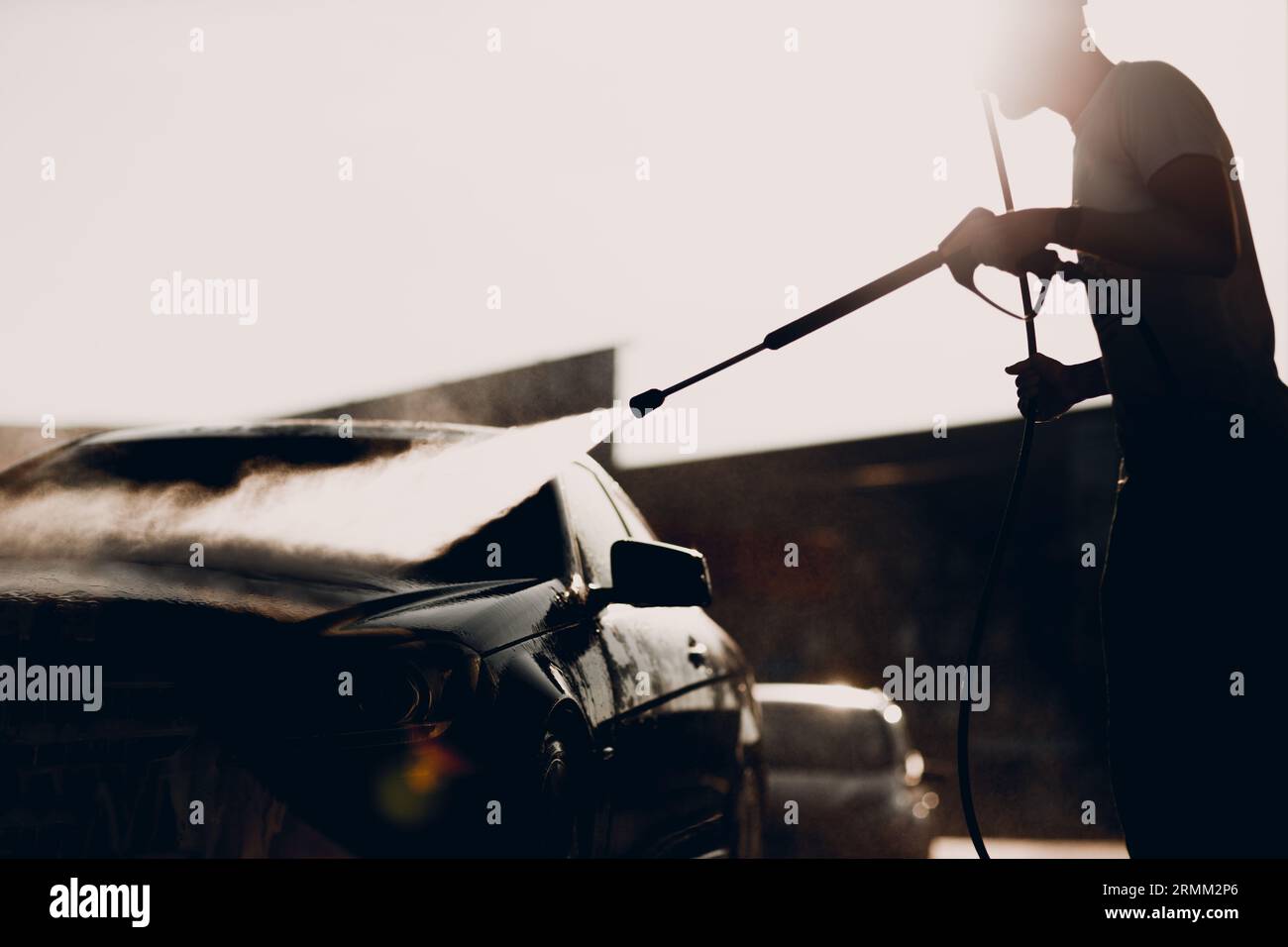 Worker man silhouette washing car at self service car wash Stock Photo ...