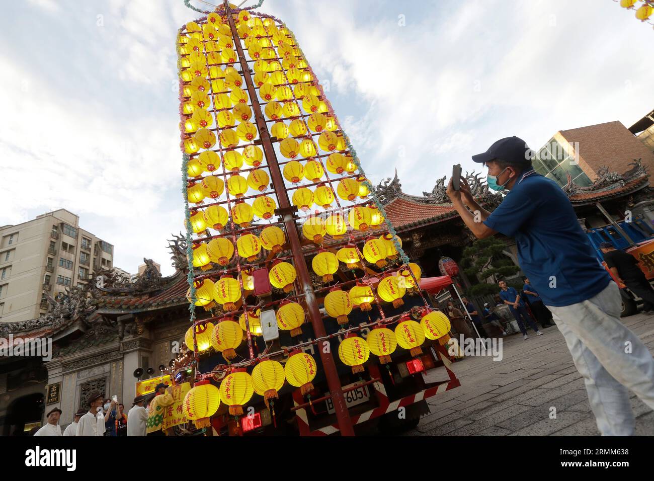 A man takes a photo of the ghost guiding lanterns during a ceremony at ...