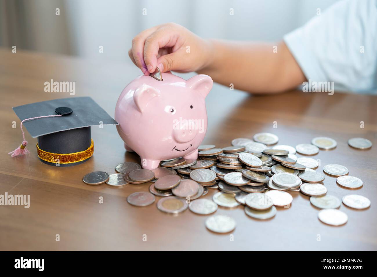 A child saving money coin into piggy bank Stock Photo - Alamy