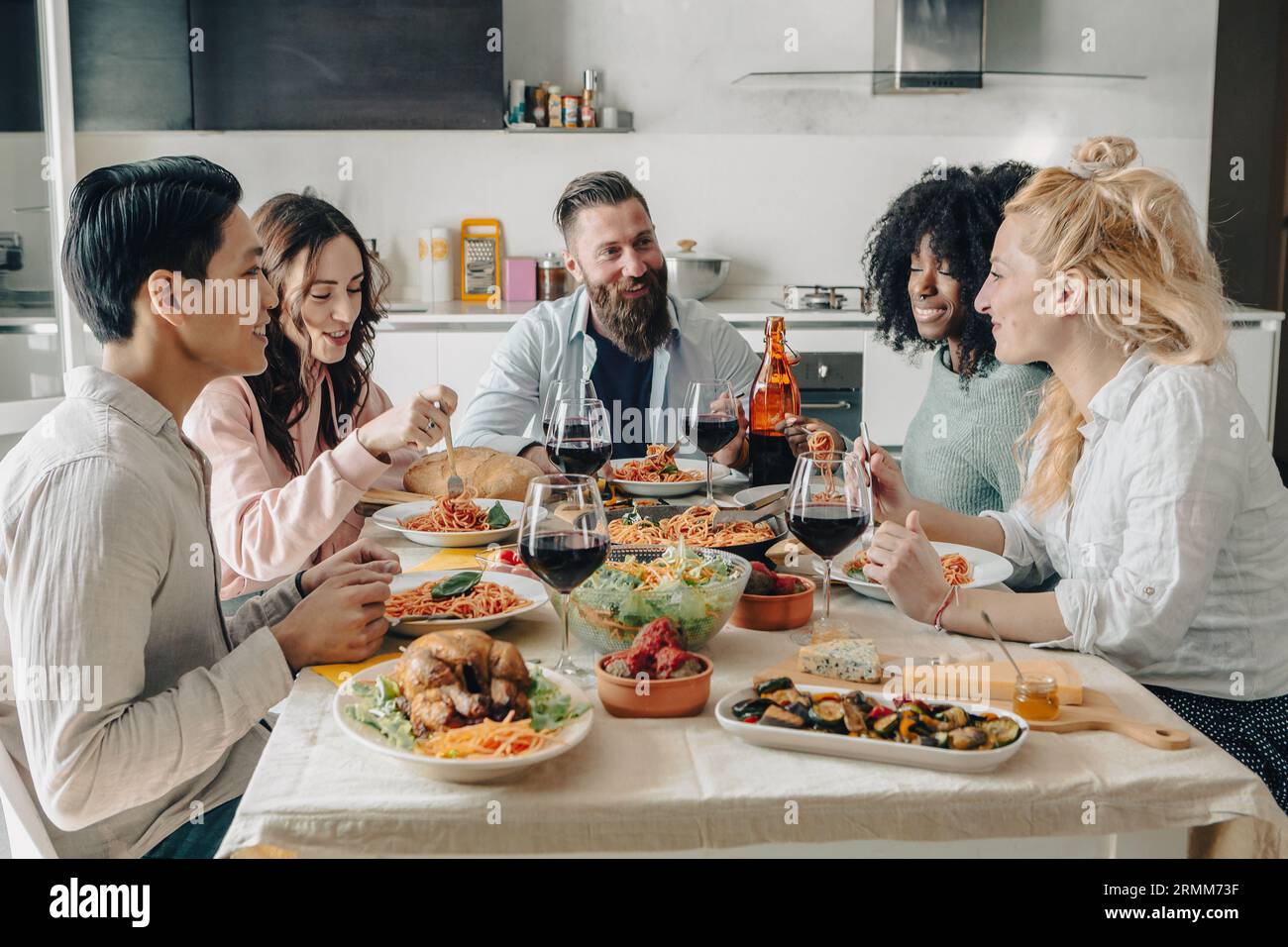 Happy group of friends having dinner party at home. Cheerful young ...