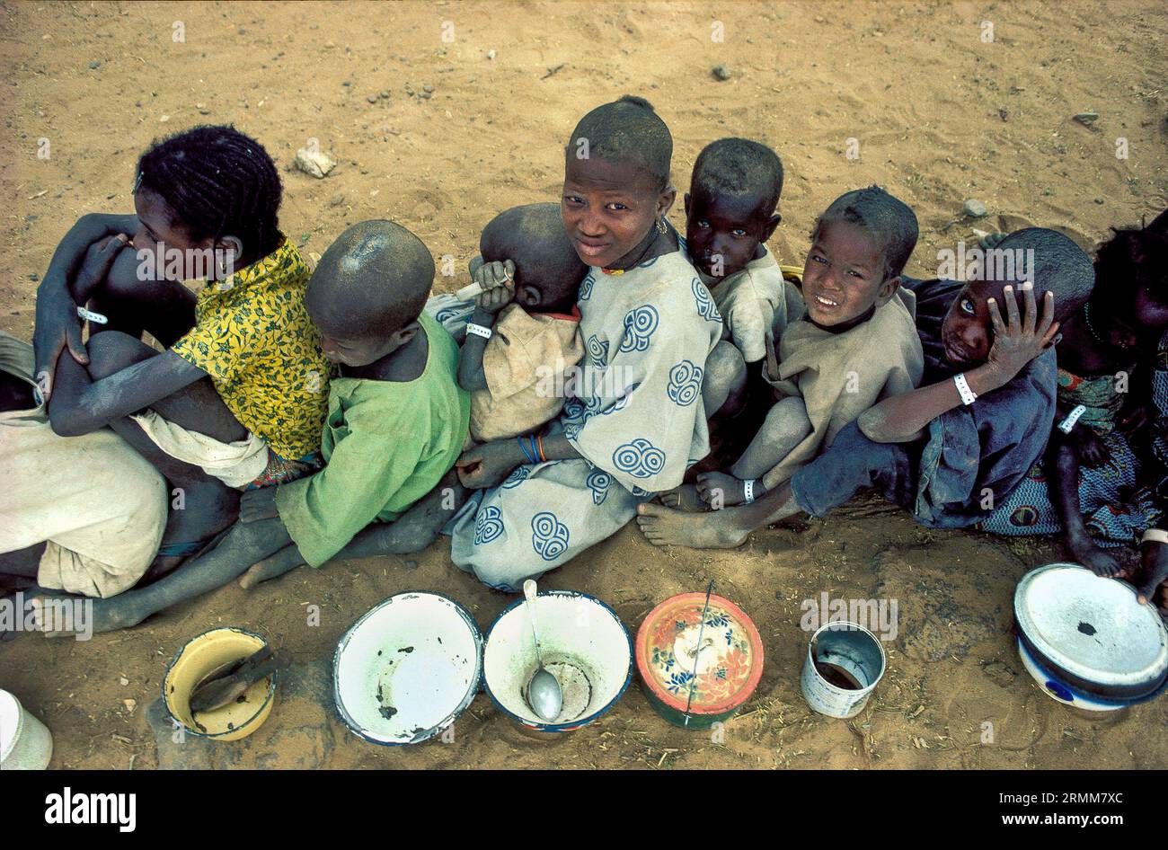 Mali, Gao. Undernourished children in line waiting for food in a red ...