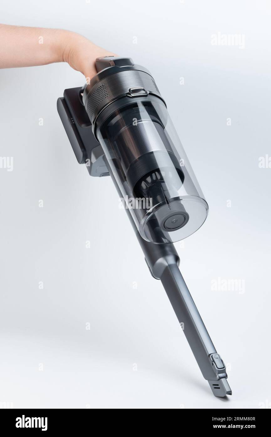 Portable gray vacuum clener in hand isolated on white studio background ...