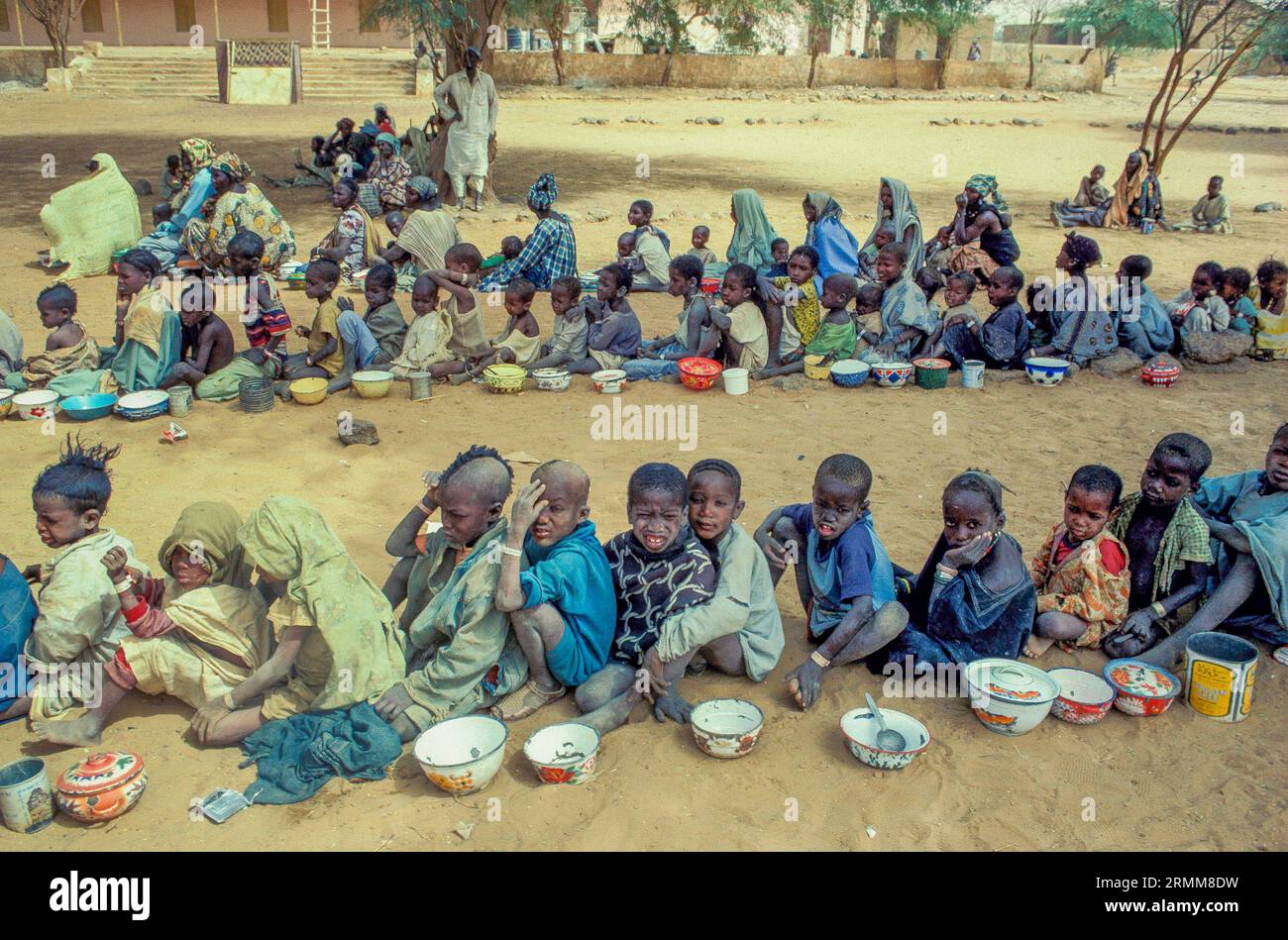 Mali, Gao. Undernourished children in line waiting for food in a red ...