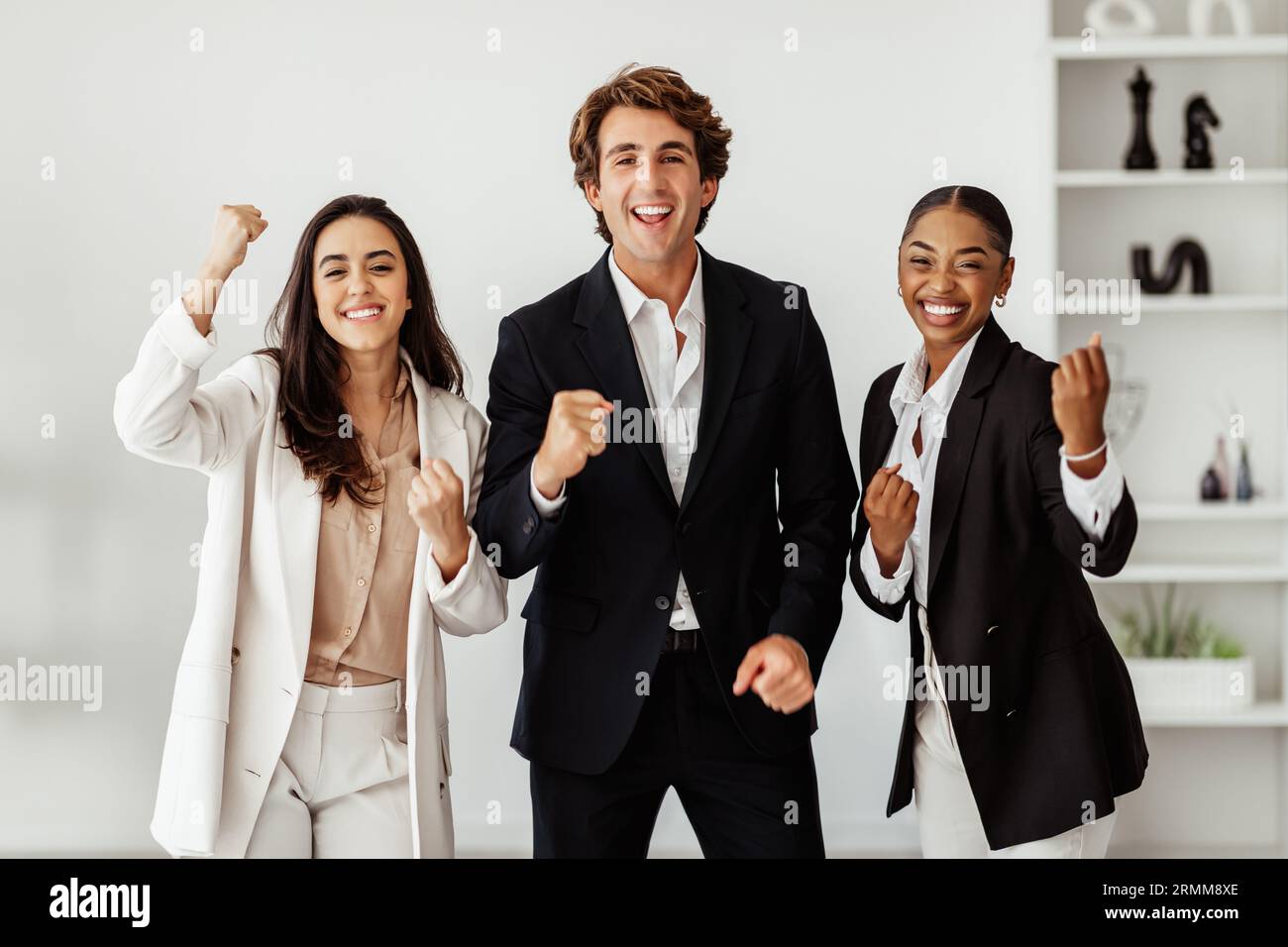 Excited multiethnic business colleagues celebrating teamwork success ...