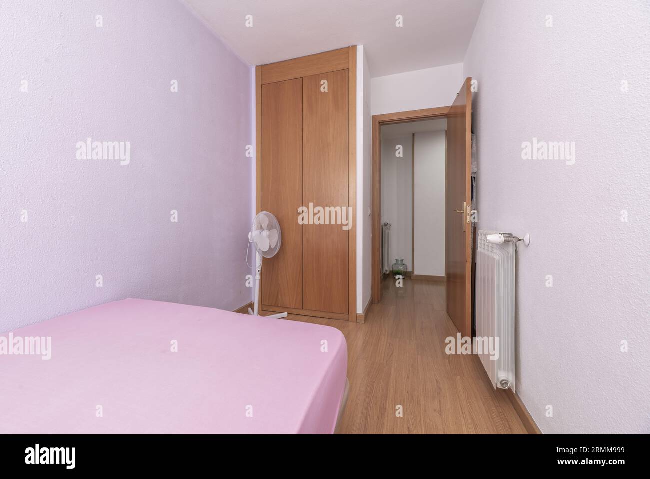 A small bedroom with few accessories and a built-in wardrobe with ...