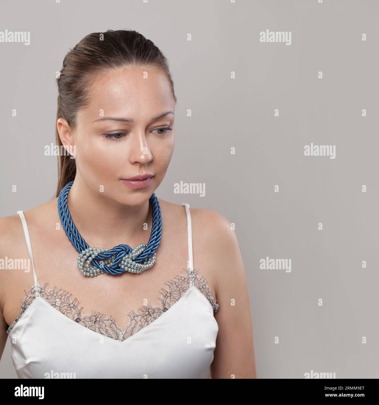 Blue and grey necklace on neck of attractive woman Stock Photo - Alamy
