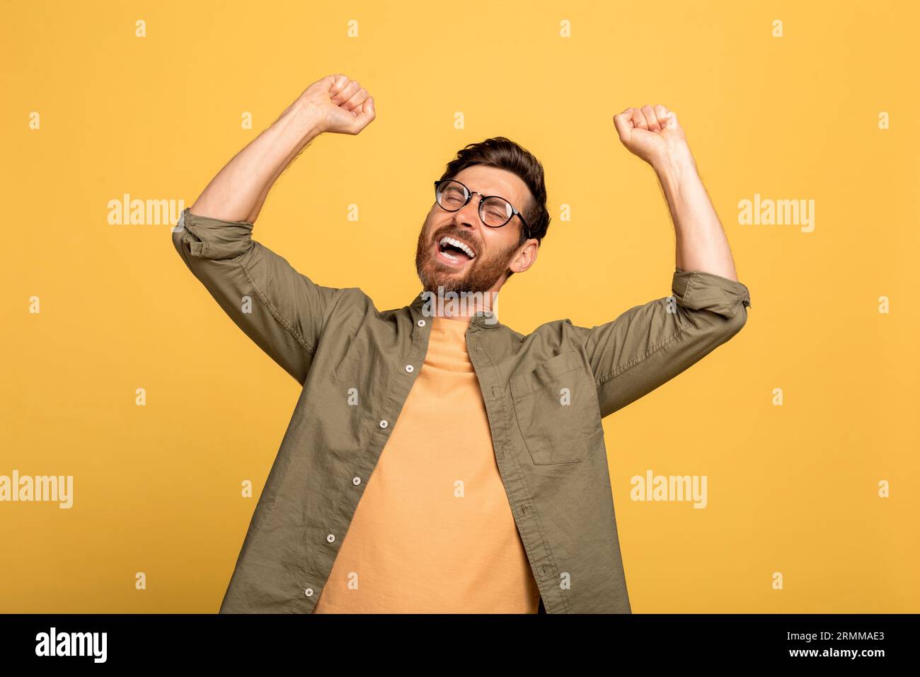 Emotional happy middle aged man exclaiming and clenching fists ...