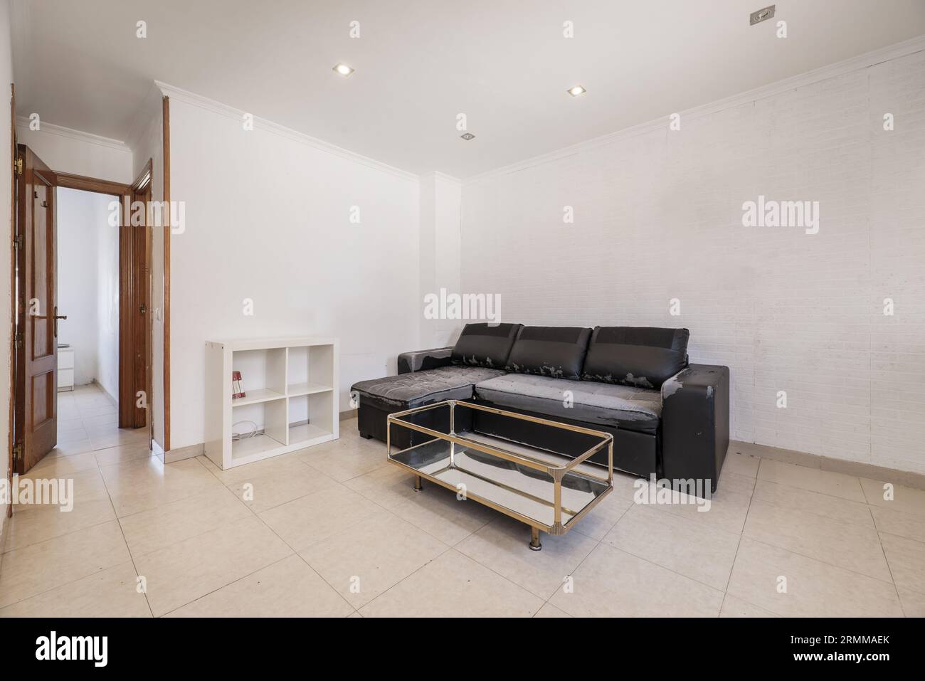 Loft apartment living room with cheap worn sofa, metal coffee table ...