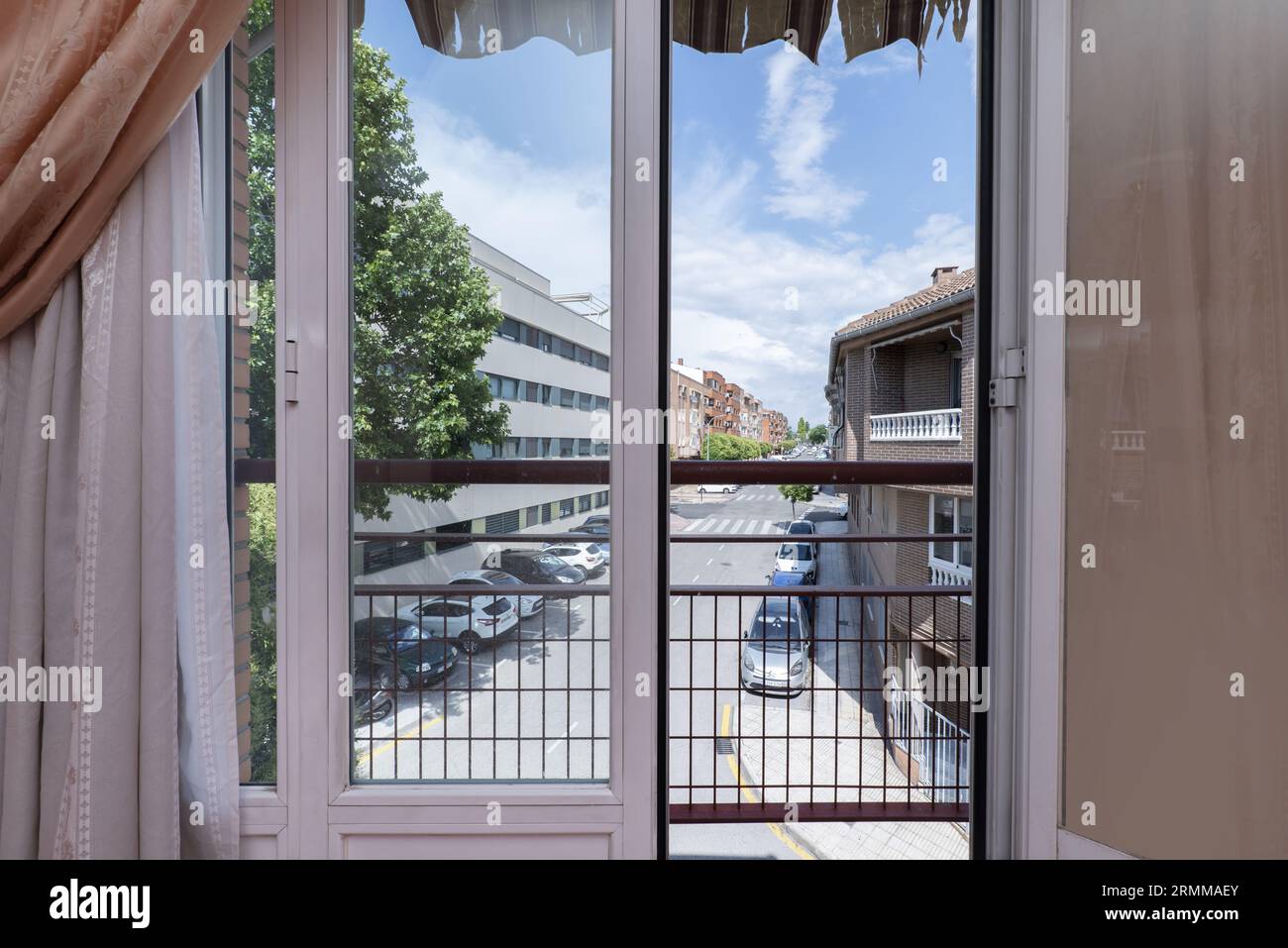 Views of the street from a window with white aluminum and glass folding ...
