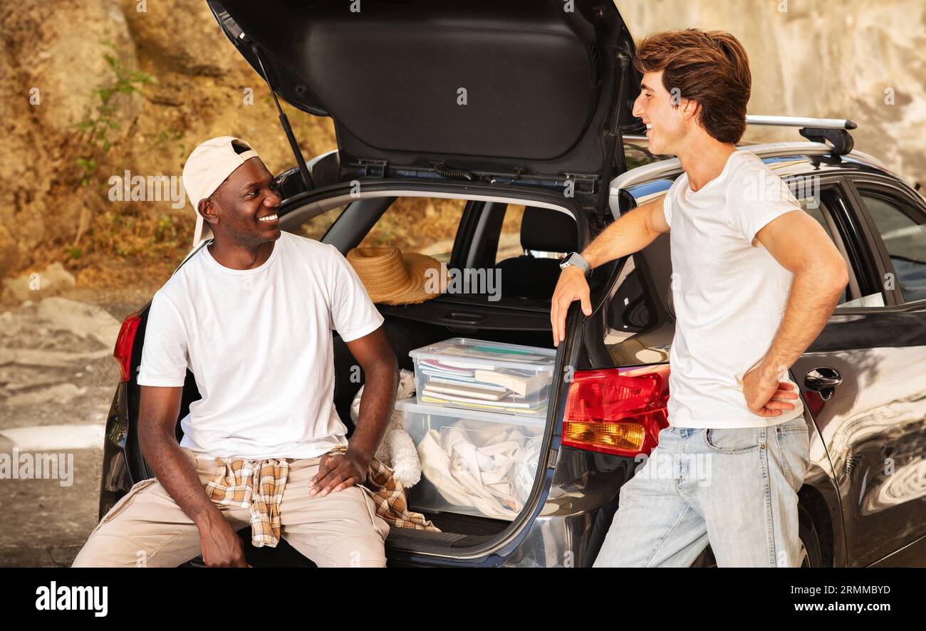 Two multiracial friends cheerful guys moving to another city Stock ...