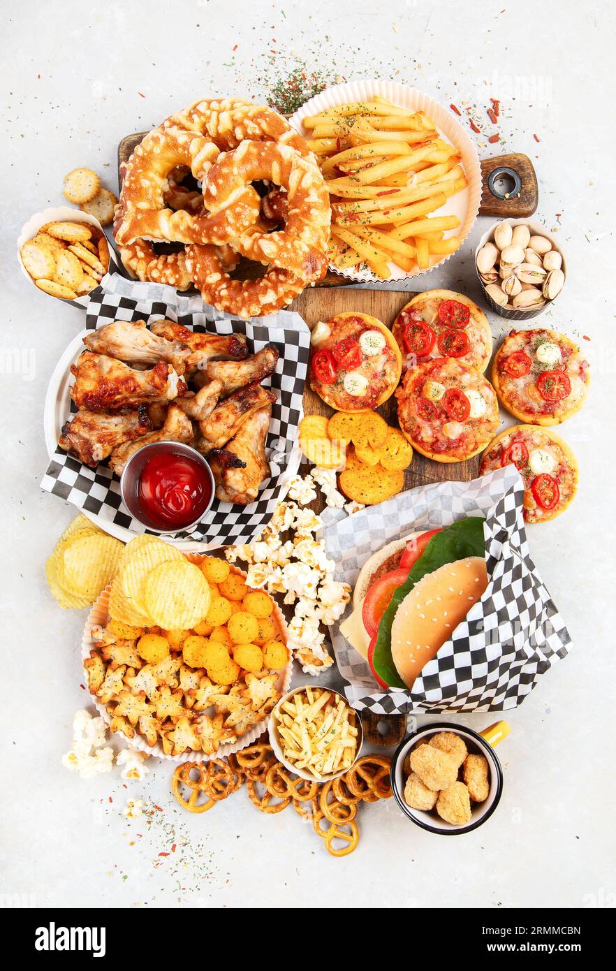 Table scene with large variety of take out and fast foods. Hamburger ...