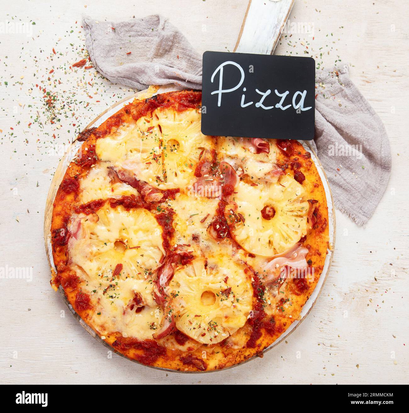 Tropical Hawaiian pizza with pineapple slices and ham on a board on a ...