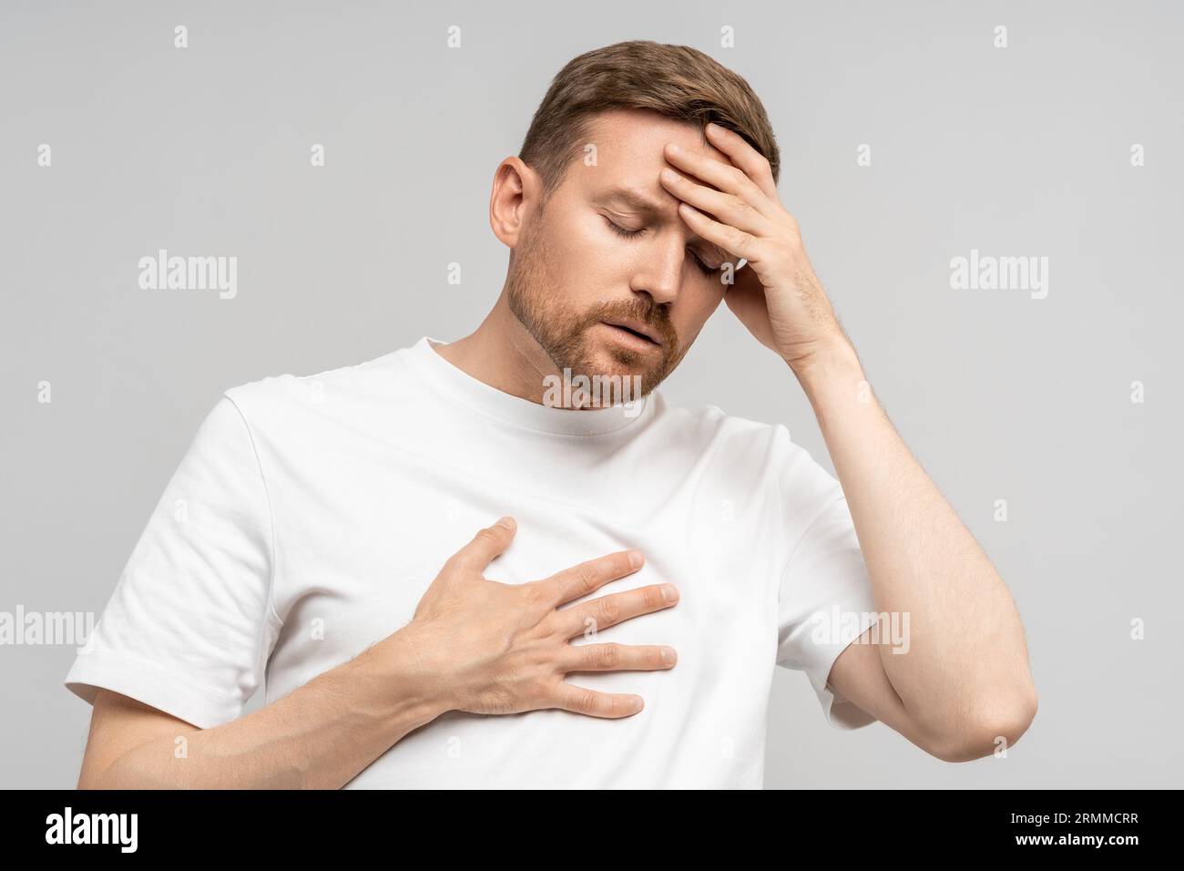 Unwell man covered forehead hand touches in region of heart feel bad ...