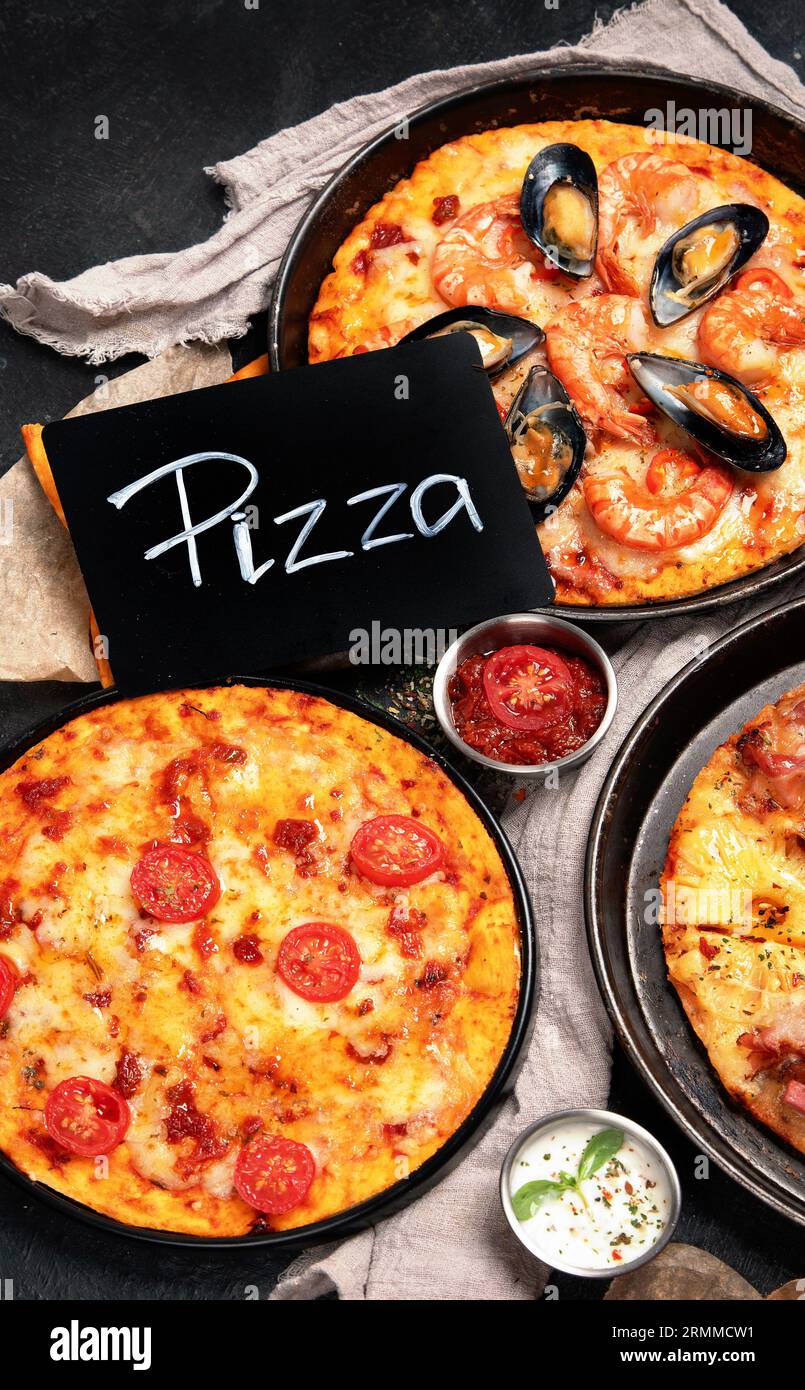 Assortment of various type of Italian pizza on a black background, top ...