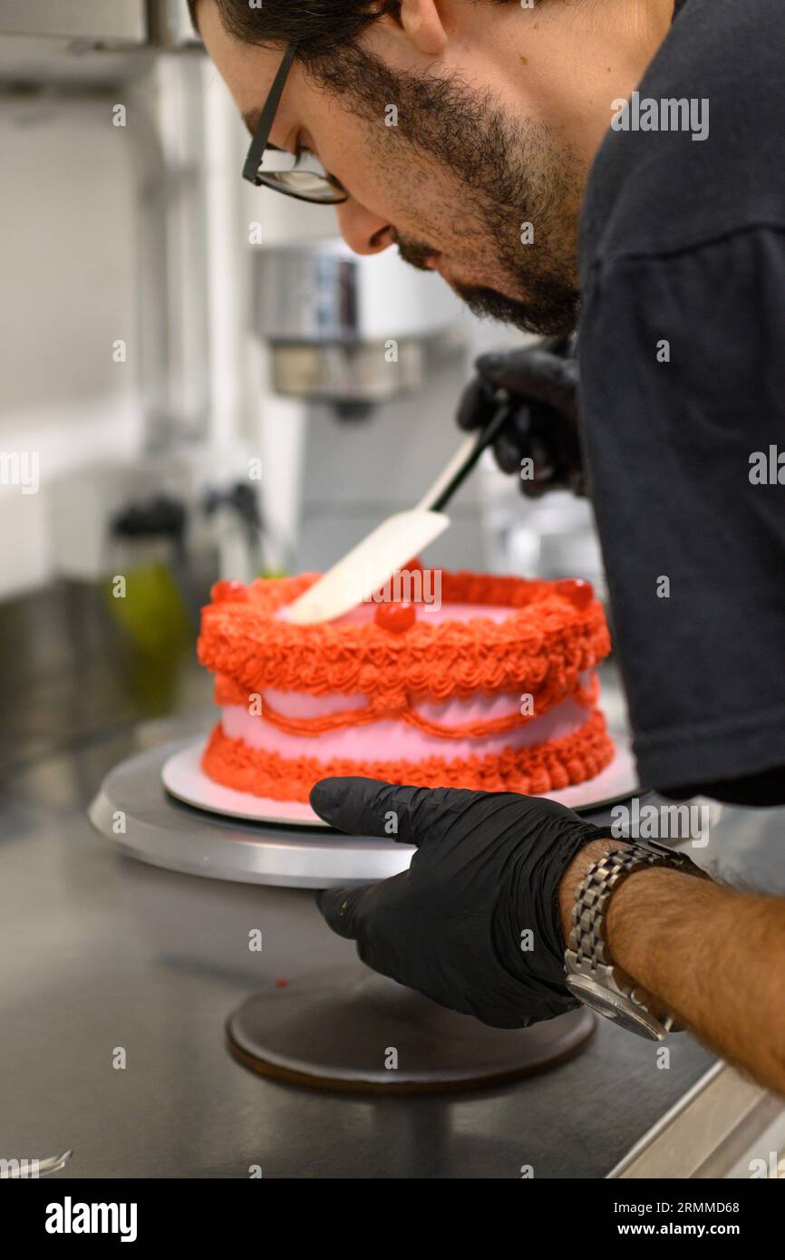 pastry chef making a pink red cupcake for birthday celebration ...