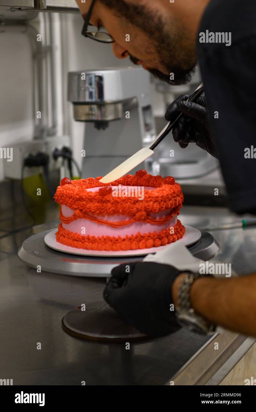 pastry chef making a pink red cupcake for birthday celebration ...
