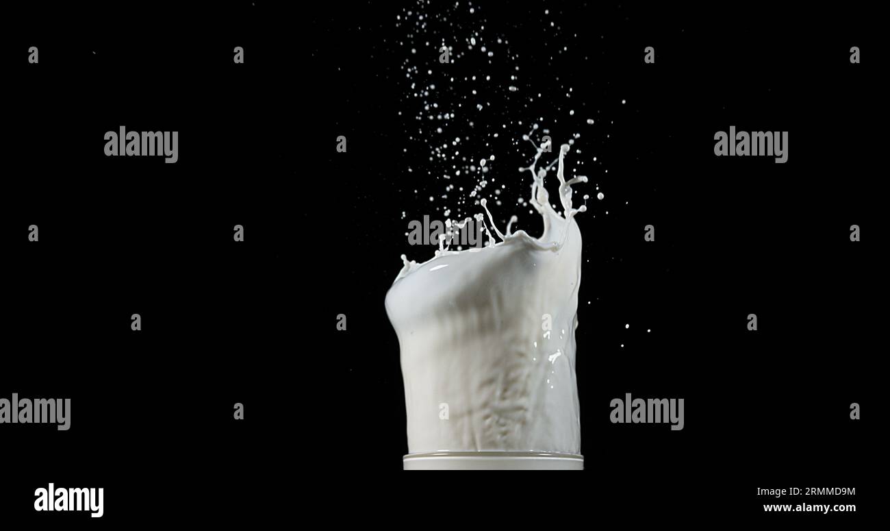 Glass of Milk Exploding against White Background Stock Photo - Alamy
