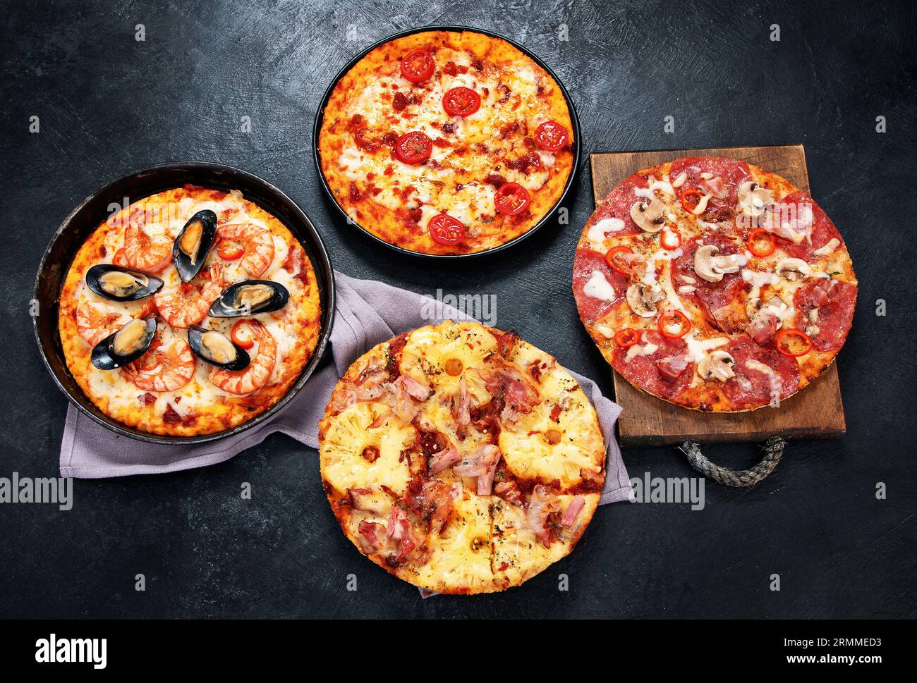 Assortment of various type of Italian pizza on a black background, top ...