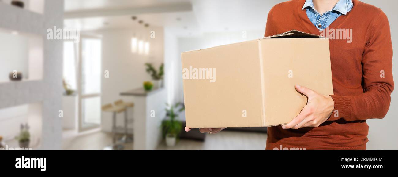 Man lifting cardboard boxes in apartment interior Stock Photo - Alamy