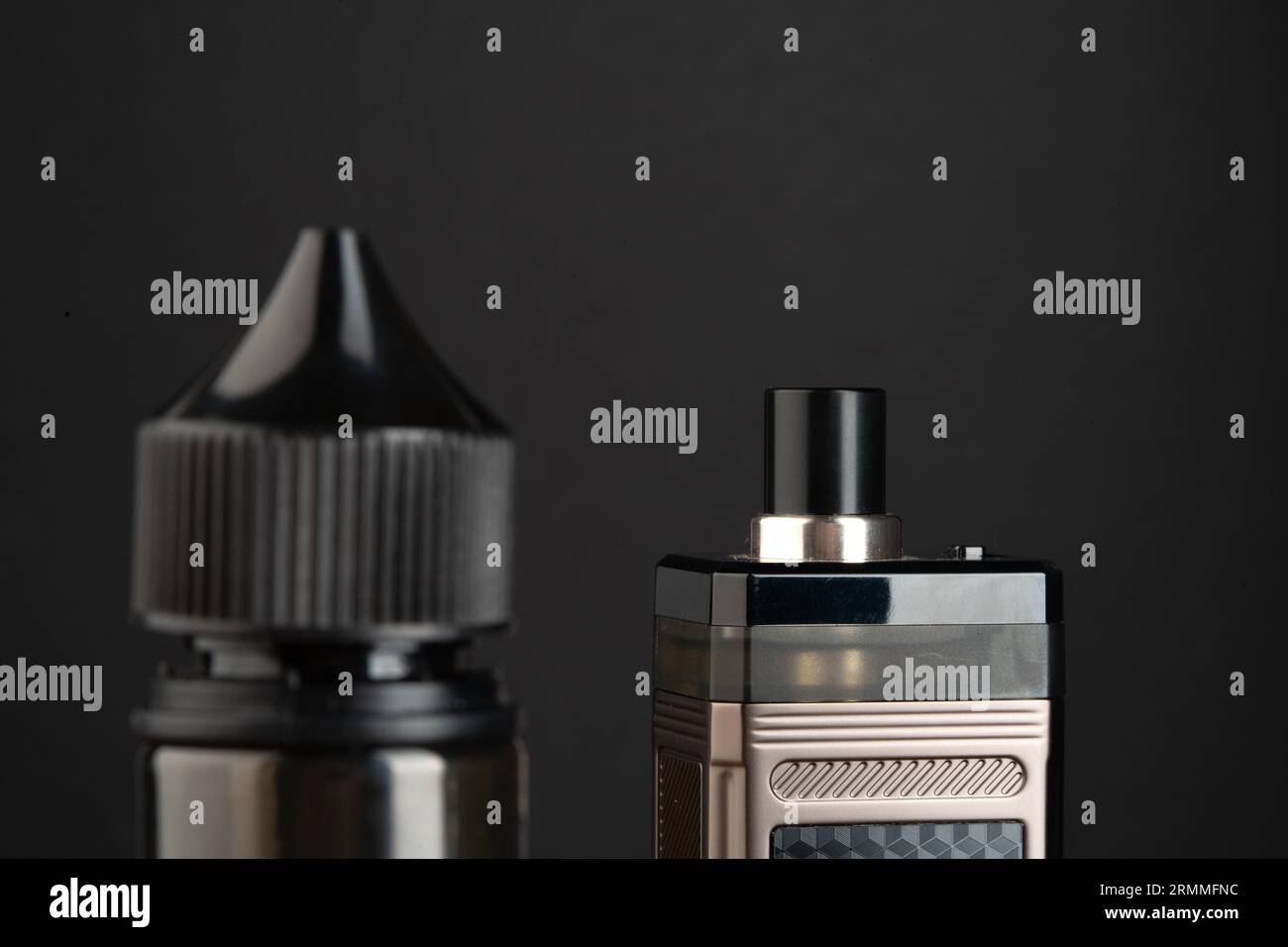 Vape and vape liquid bottles against black background Stock Photo - Alamy