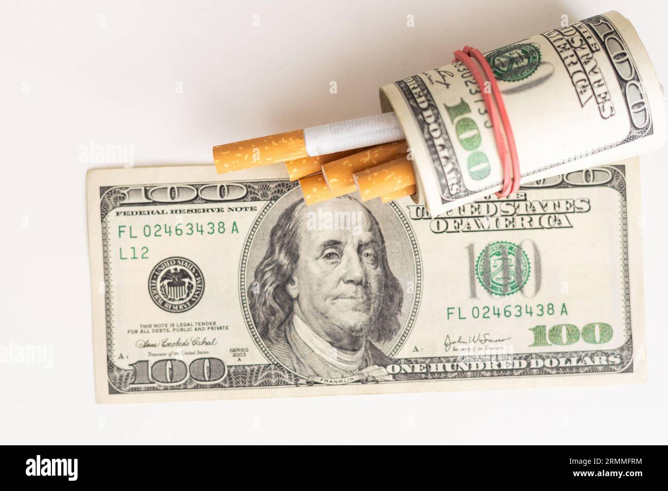 cigarettes and money. expensive habit. white background - horizontal ...
