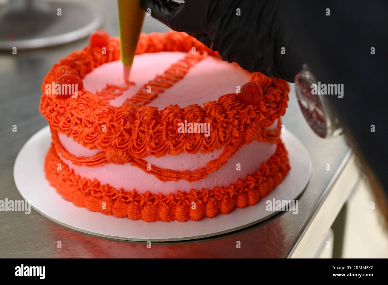 pastry chef making a pink red cupcake for birthday celebration , write ...