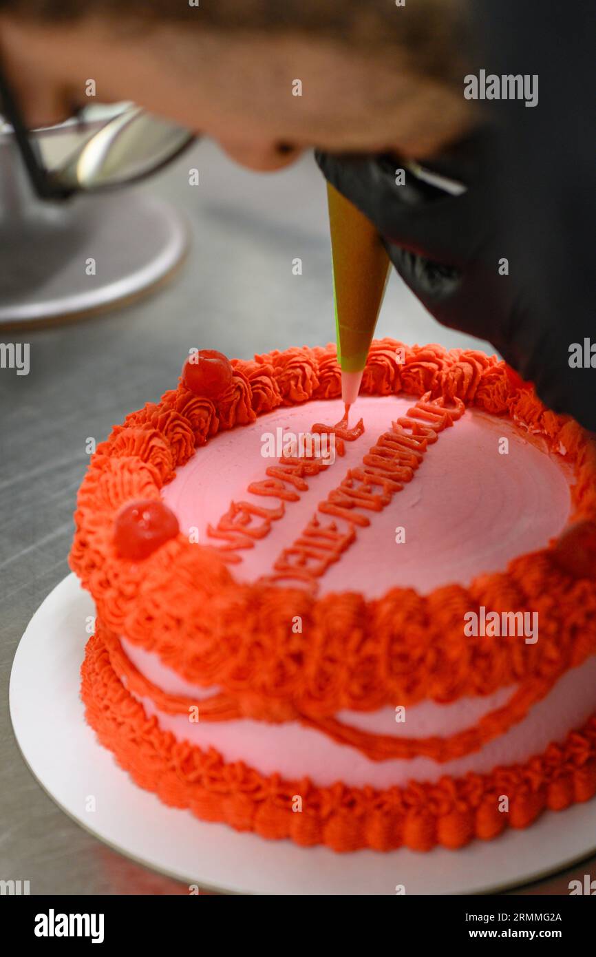 pastry chef making a pink red cupcake for birthday celebration , write ...