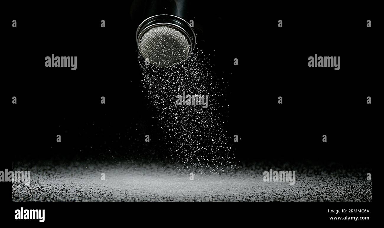 White Sugar falling against Black Background Stock Photo - Alamy
