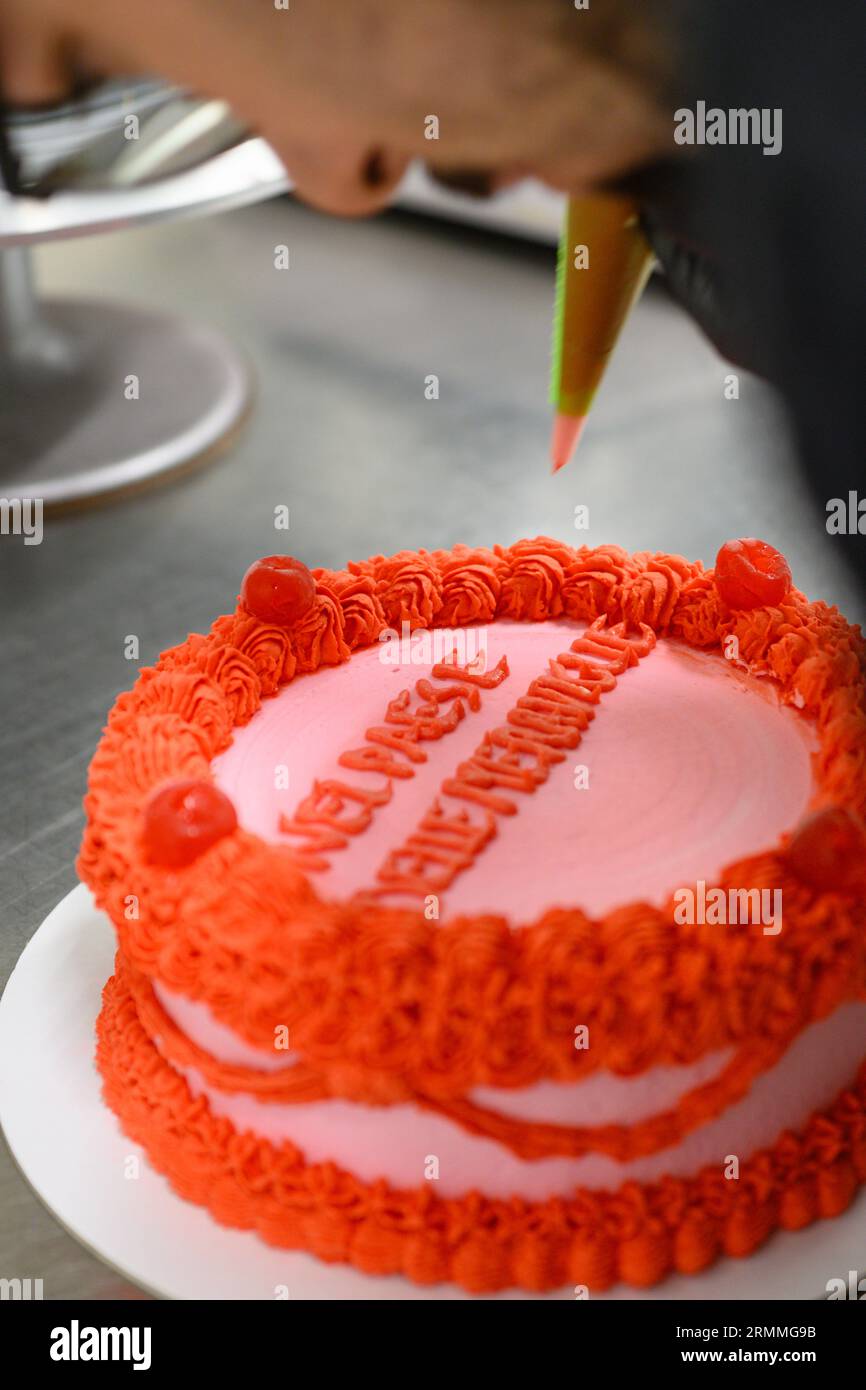 pastry chef making a pink red cupcake for birthday celebration , write ...