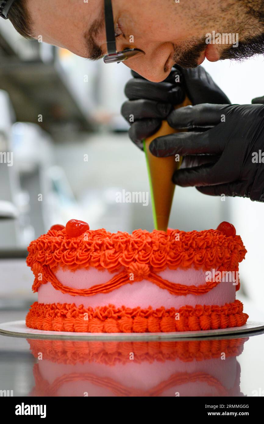 pastry chef making a pink red cupcake for birthday celebration , write ...
