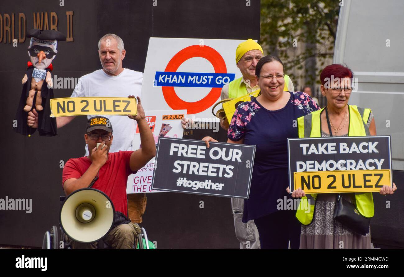 Protesters hold anti-ULEZ placards during the demonstration. Anti-ULEZ ...