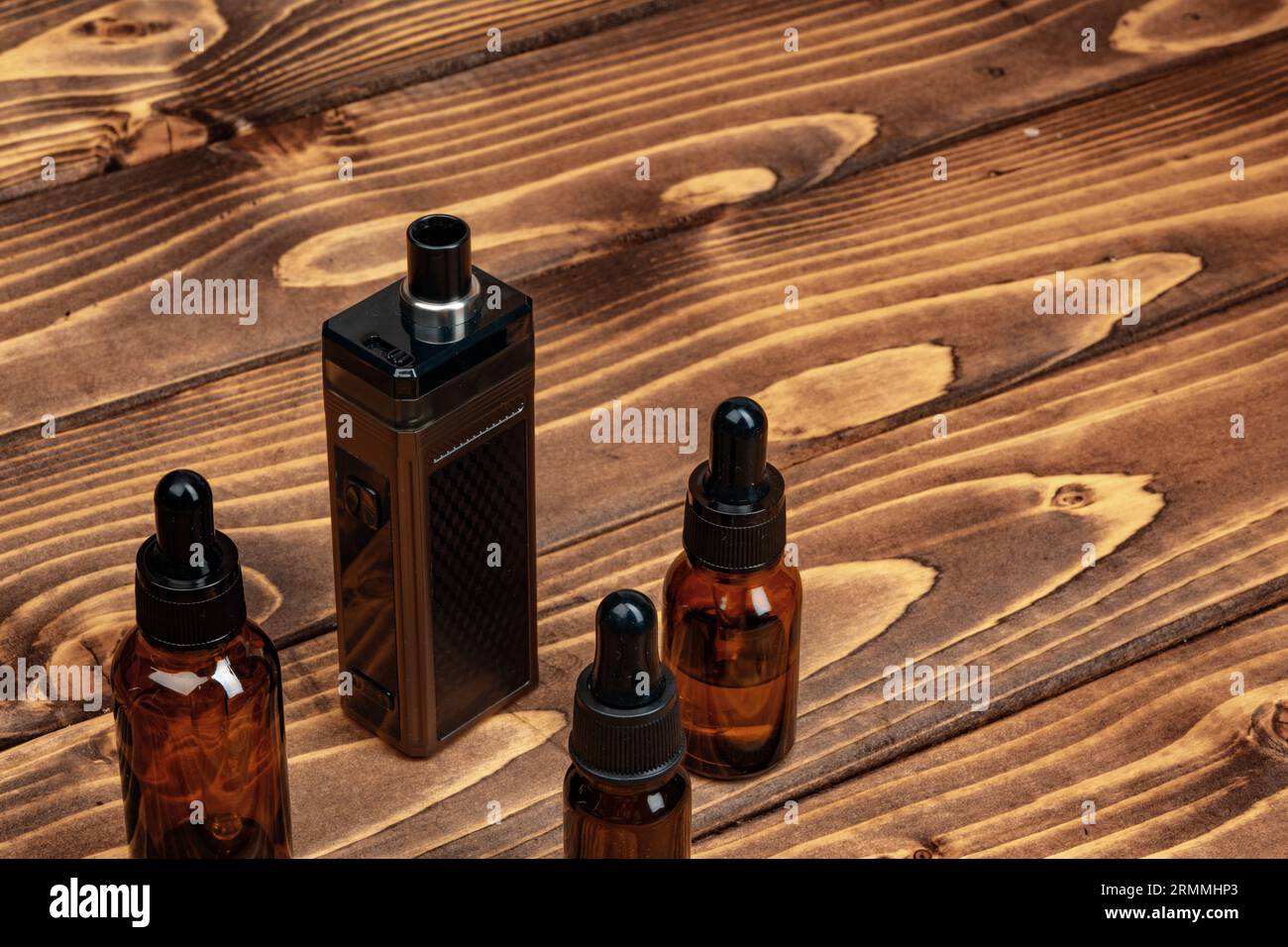 Vape and vape juice bottles on brown wooden background Stock Photo - Alamy
