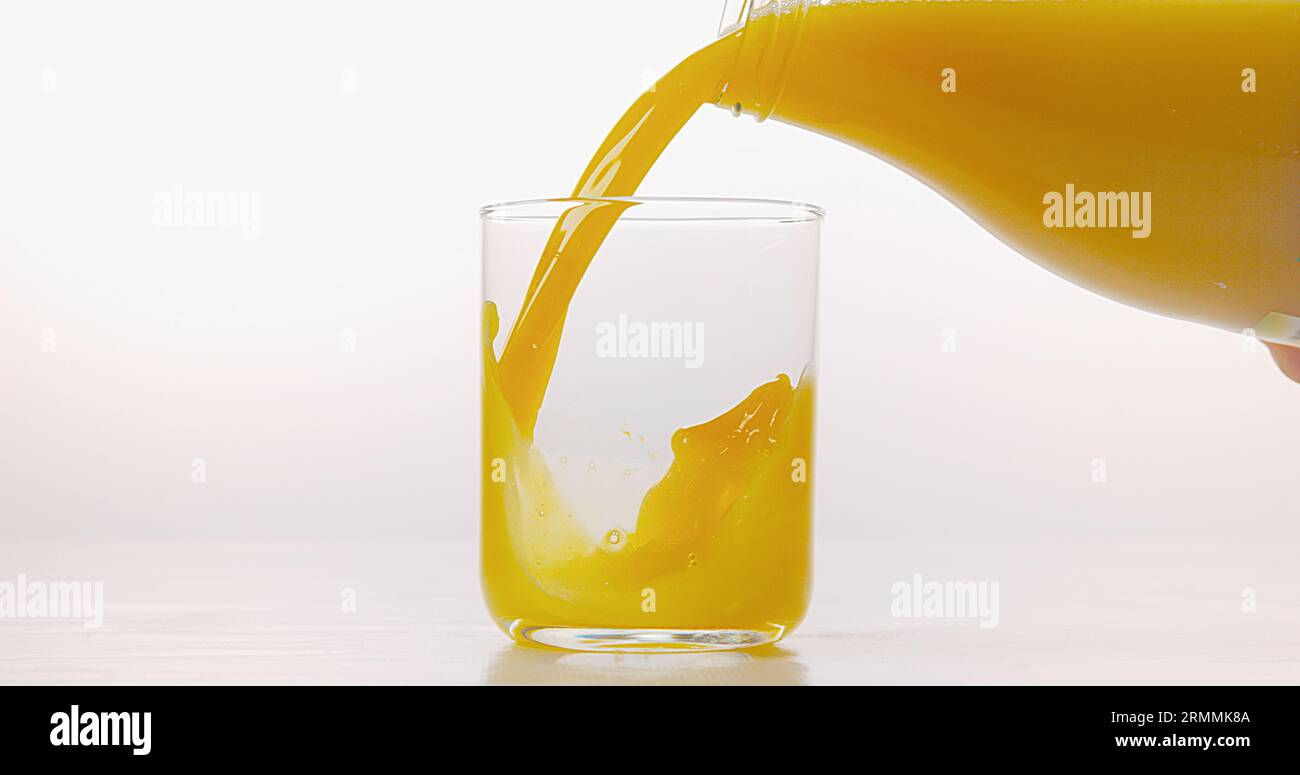 Orange Juice being poured into Glass against White Background Stock ...