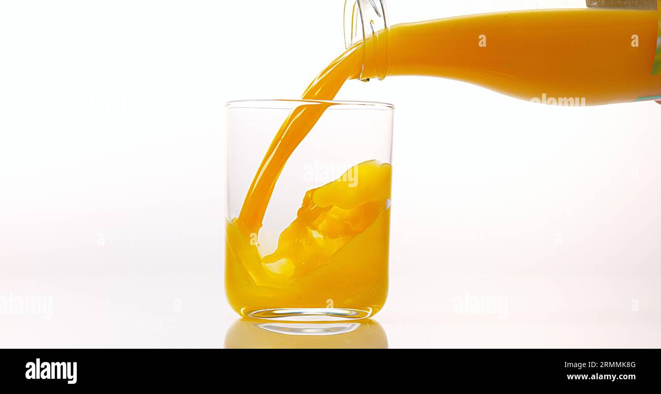 Orange Juice being poured into Glass against White Background Stock ...