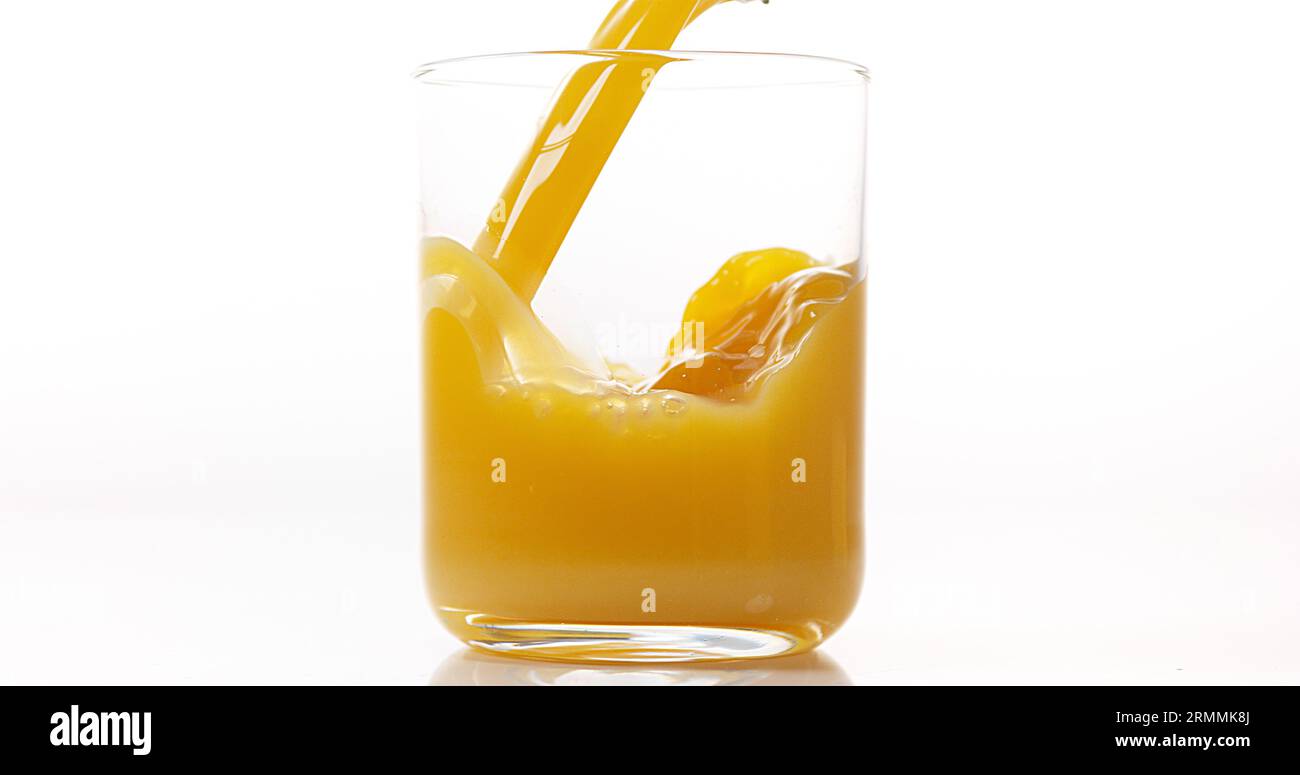 Orange Juice being poured into Glass against White Background Stock ...