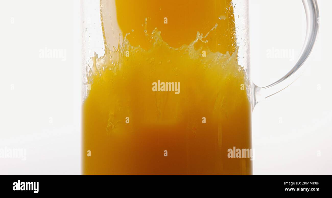 Orange Juice being poured into Glass against White Background Stock ...