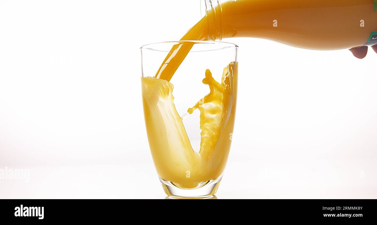 Orange Juice being poured into Glass against White Background Stock ...