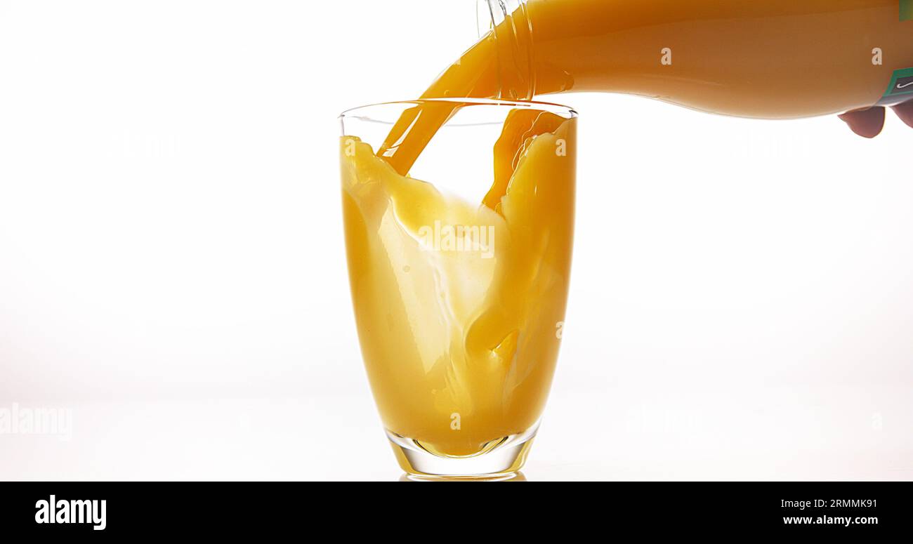Orange Juice being poured into Glass against White Background Stock ...