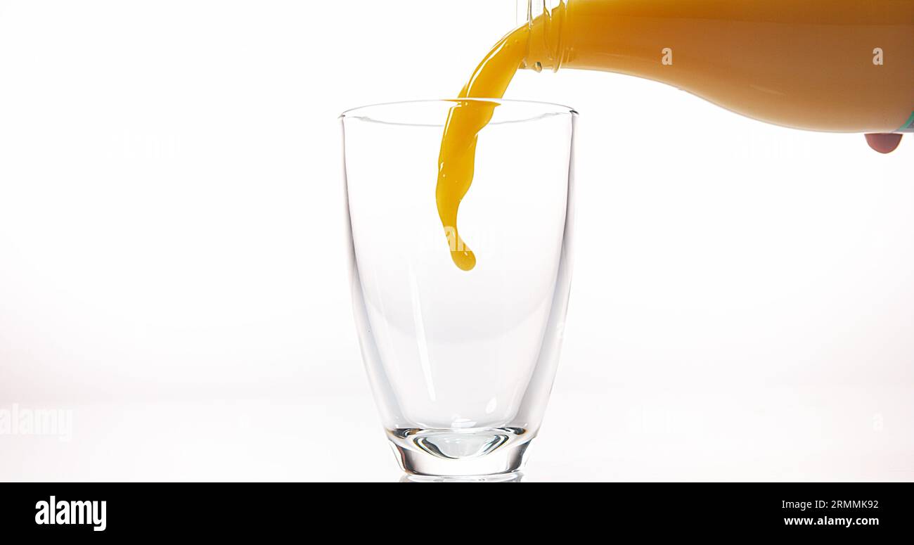 Orange Juice being poured into Glass against White Background Stock ...